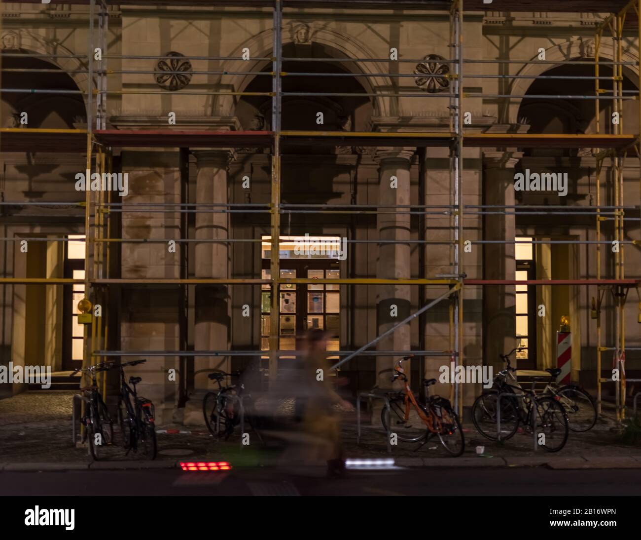 A cyclist drives past an old building in the dark Stock Photo - Alamy