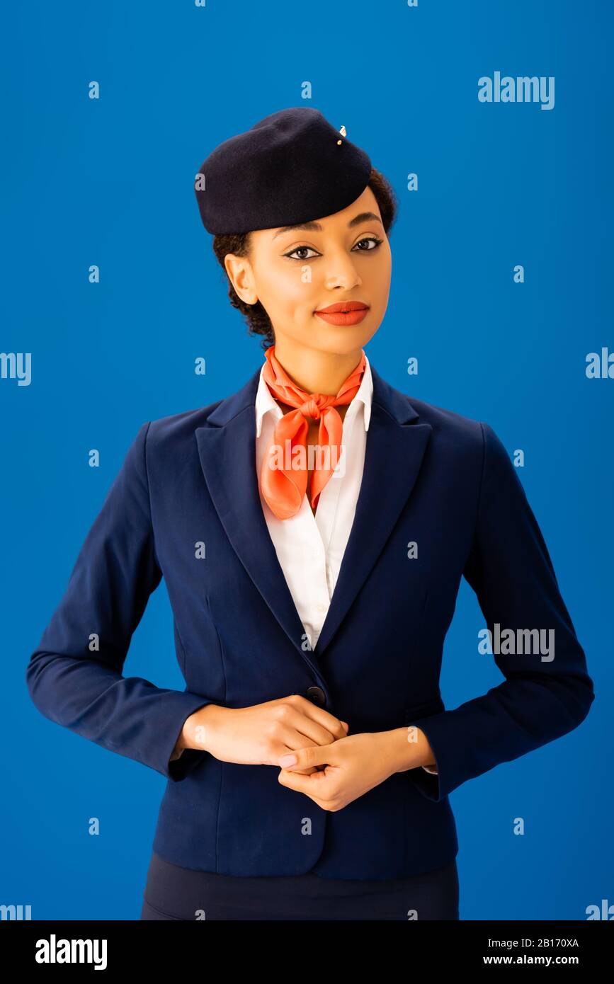 smiling african american flight attendant looking at camera isolated on ...