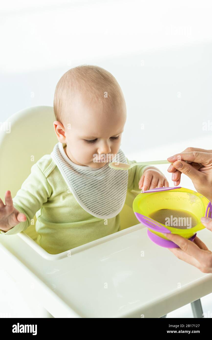 High angle view of mother with baby food feeding adorable infant on ...