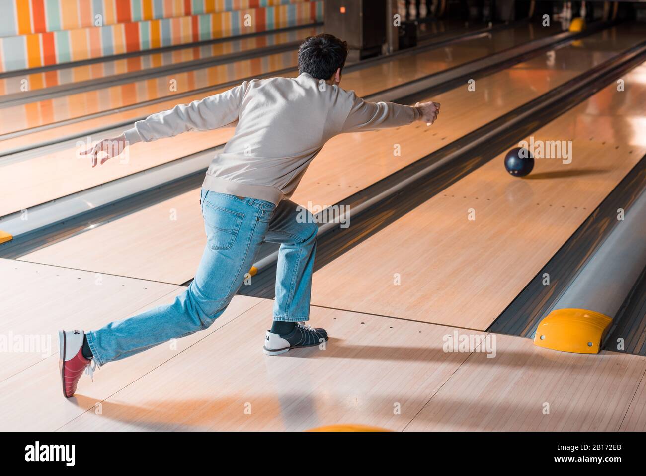 back view of young man throwing bowling ball on skittle alley Stock ...