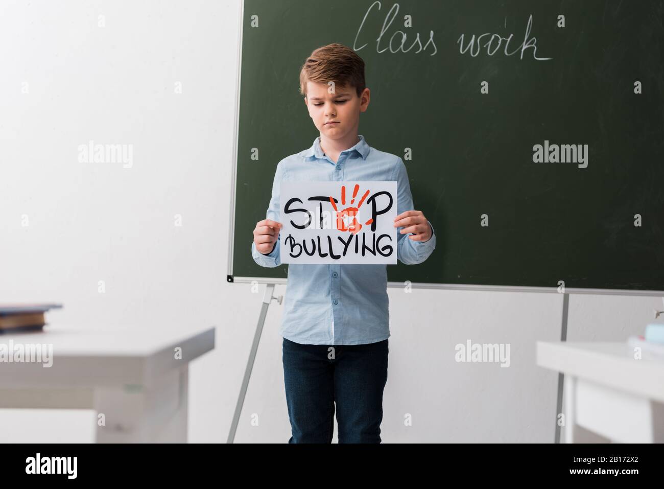 selective focus of schoolchild holding placard with stop bullying ...