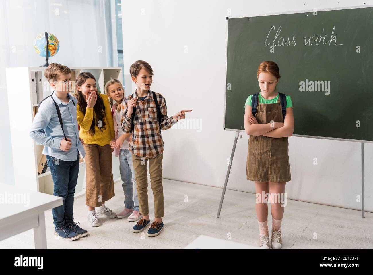 cruel schoolkid pointing with finger and laughing near bullied ...