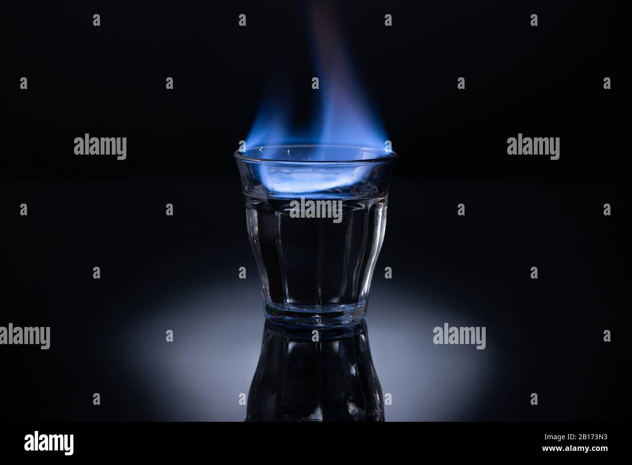 transparent glass with burning liquid on black background Stock Photo ...