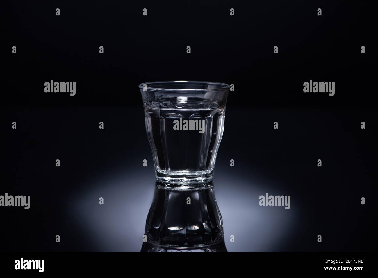 transparent glass with liquid on black background Stock Photo - Alamy