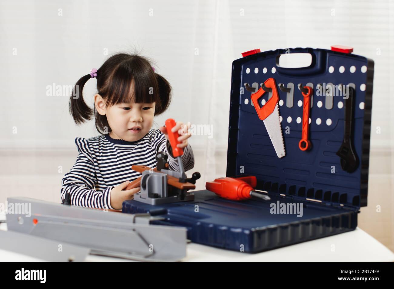 toddler girl pretend using DIY tool at home against white background ...