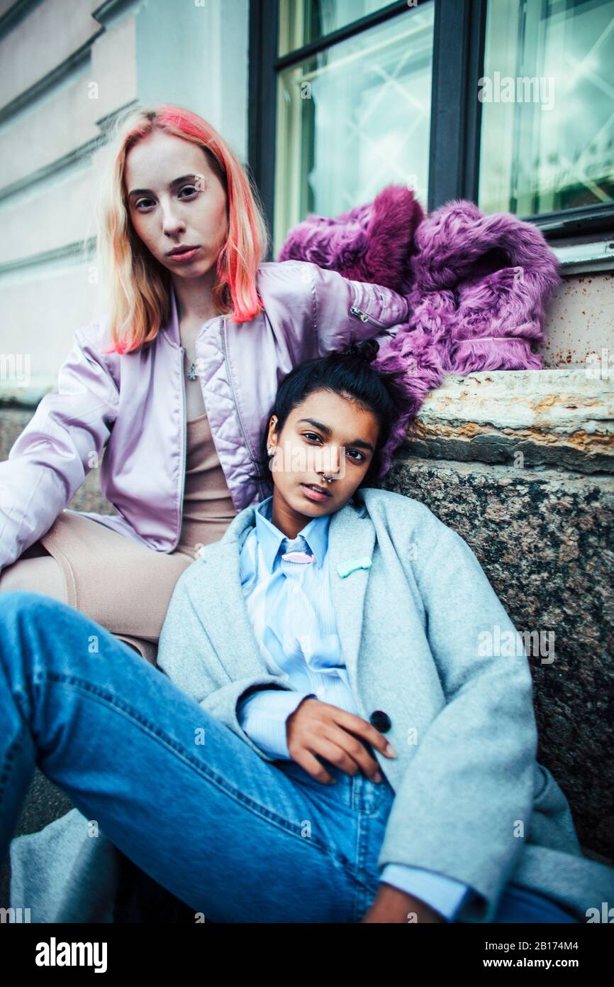 Two teenage girls infront of university building smiling, having fun ...