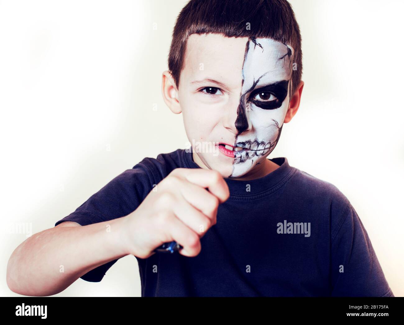 little cute boy with facepaint like skeleton to celebrate halloween ...