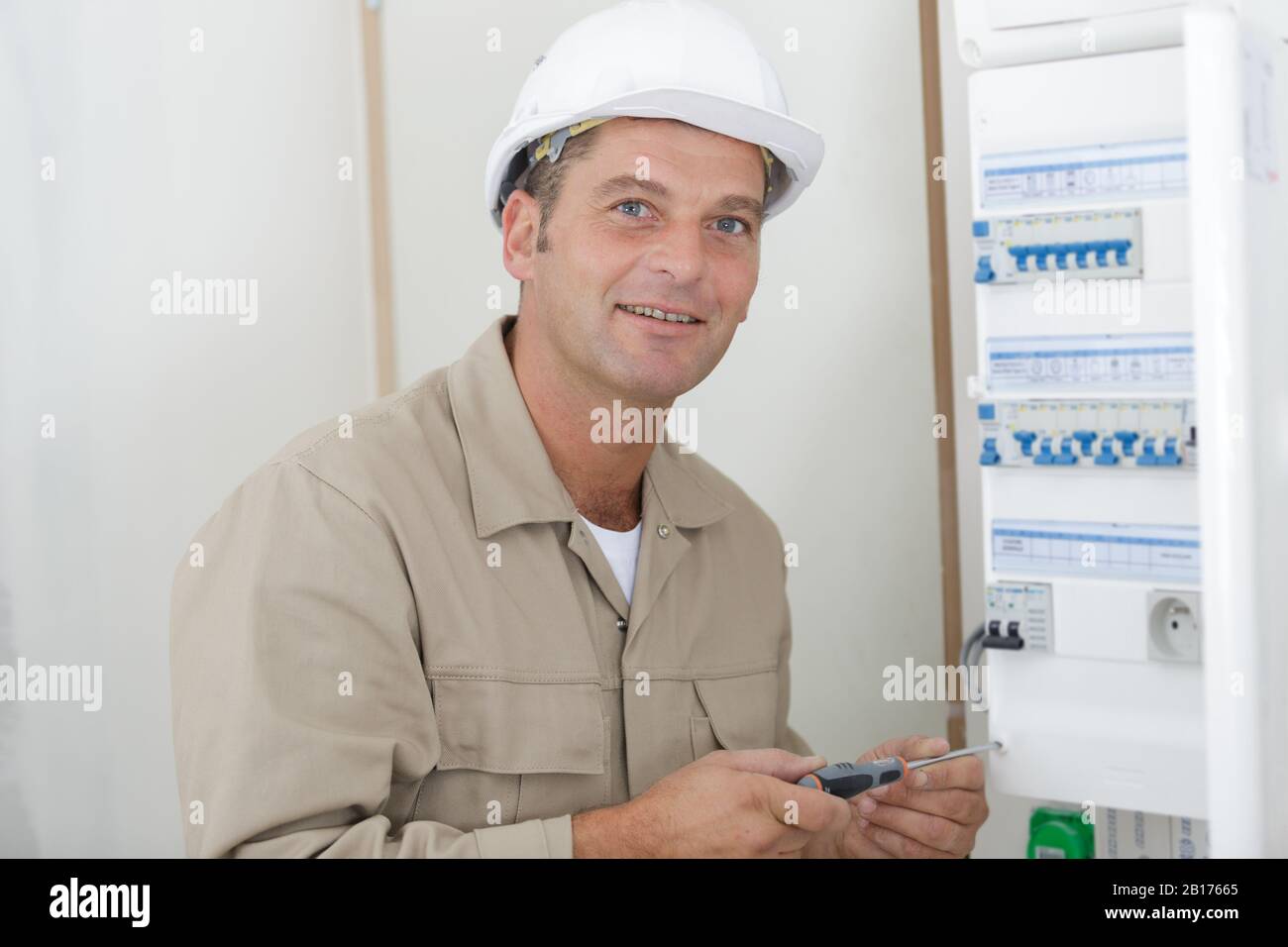 male electrician using screwdriver on circuit-breaker box Stock Photo ...