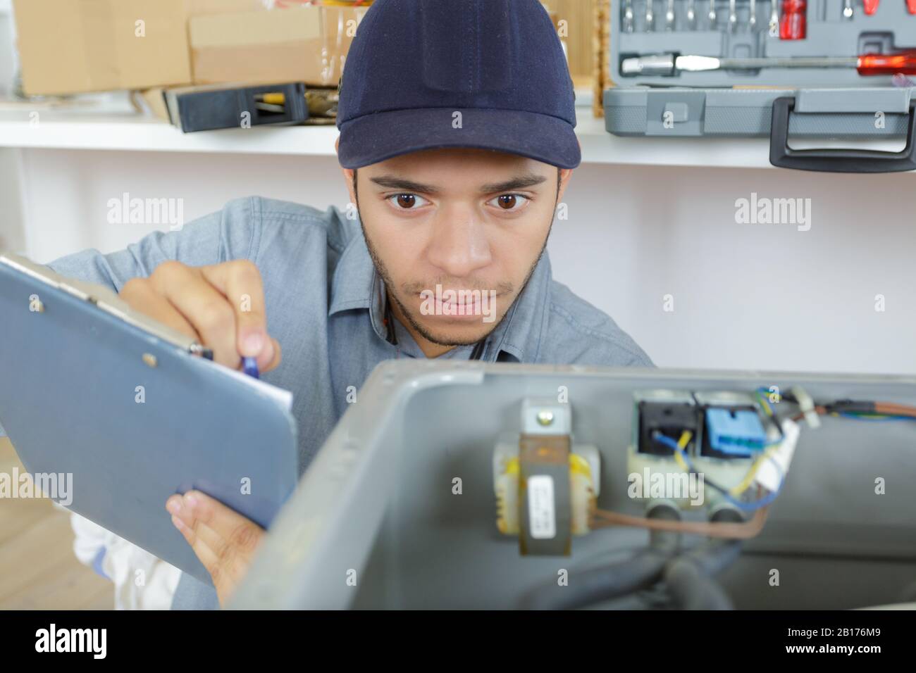 male builder writing on clipboard Stock Photo - Alamy