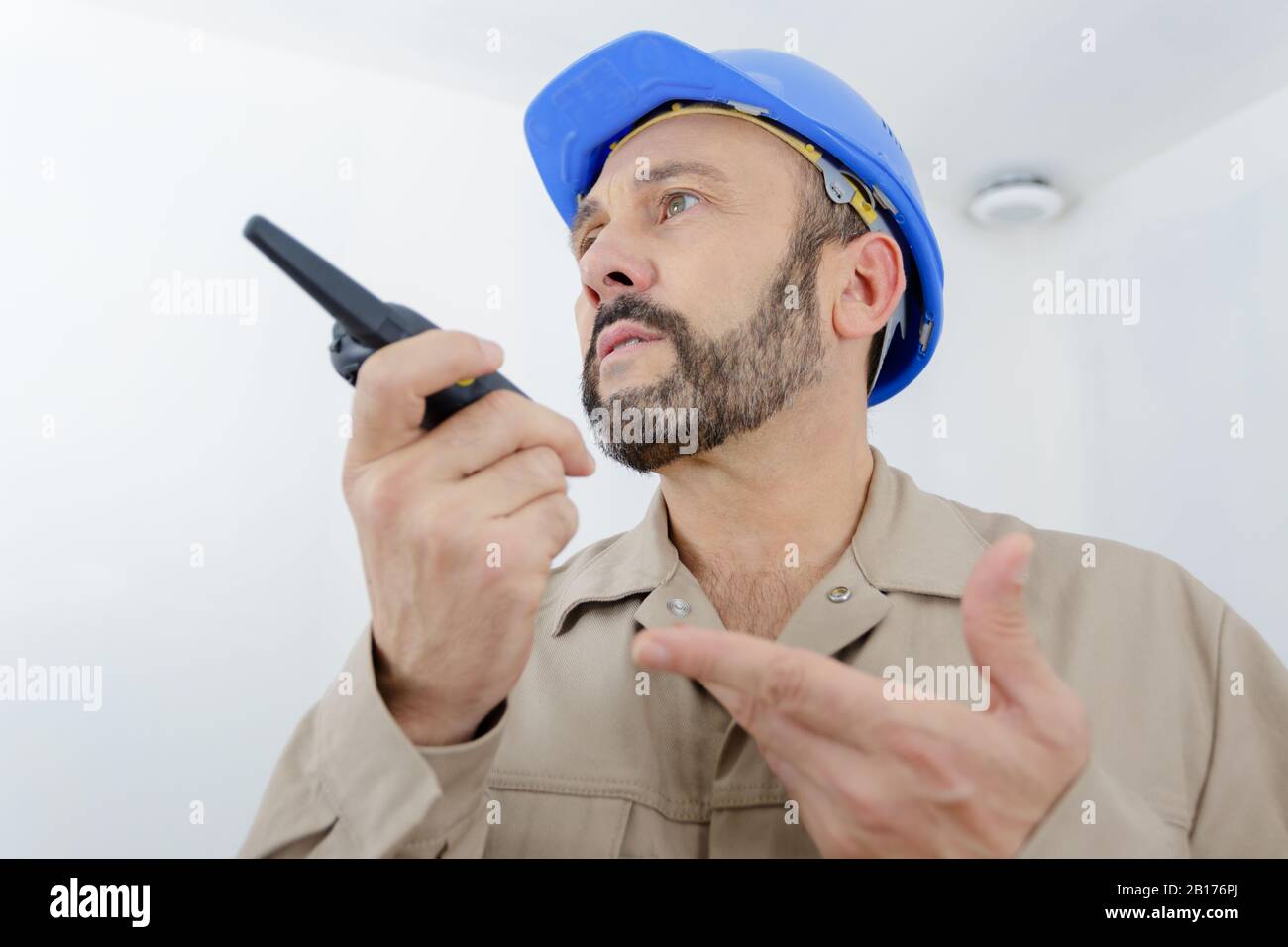 worker in helmet using walkie talkie Stock Photo - Alamy
