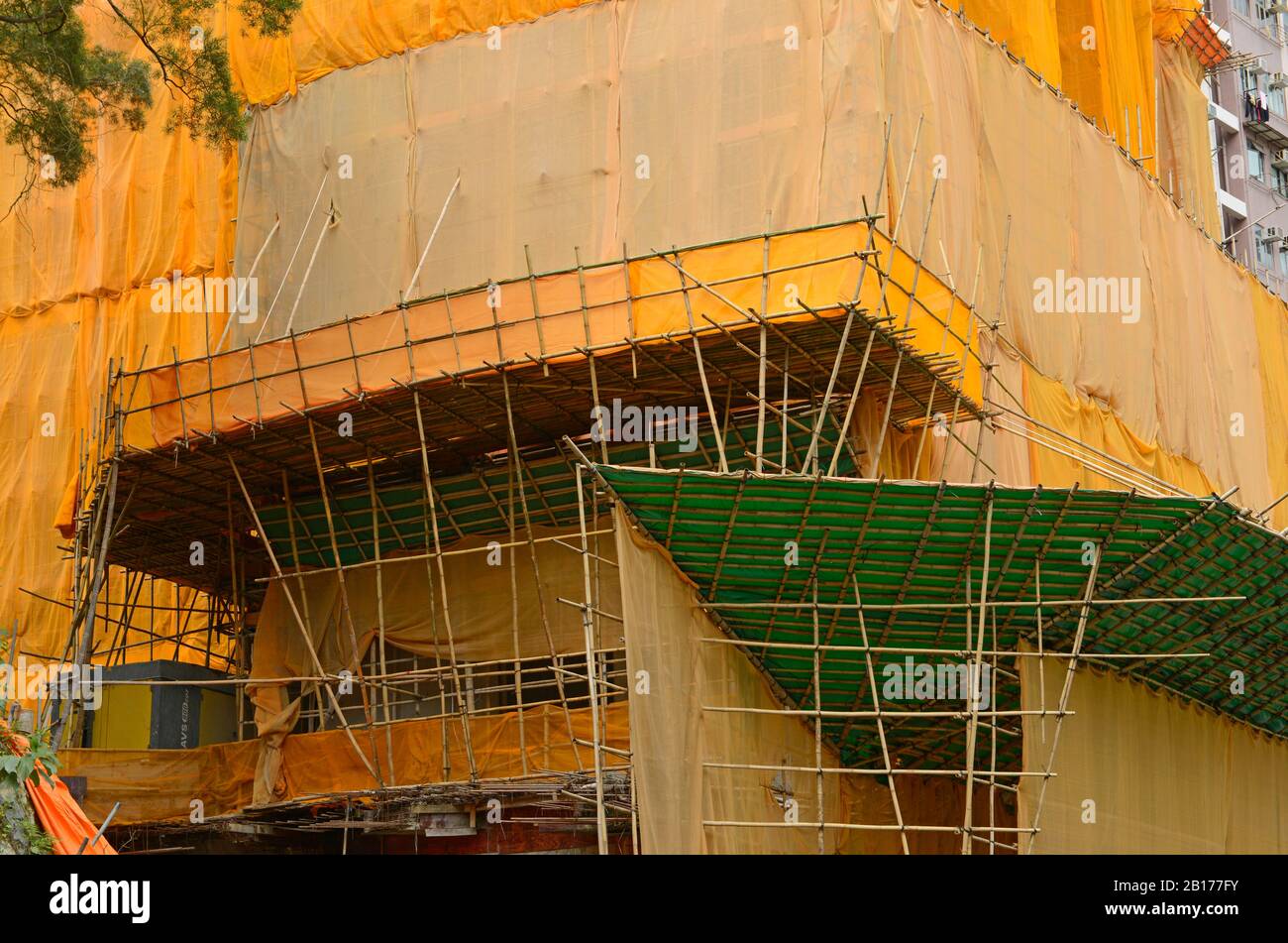 Bamboo scaffolding covers a building under construction in Chai Wan ...