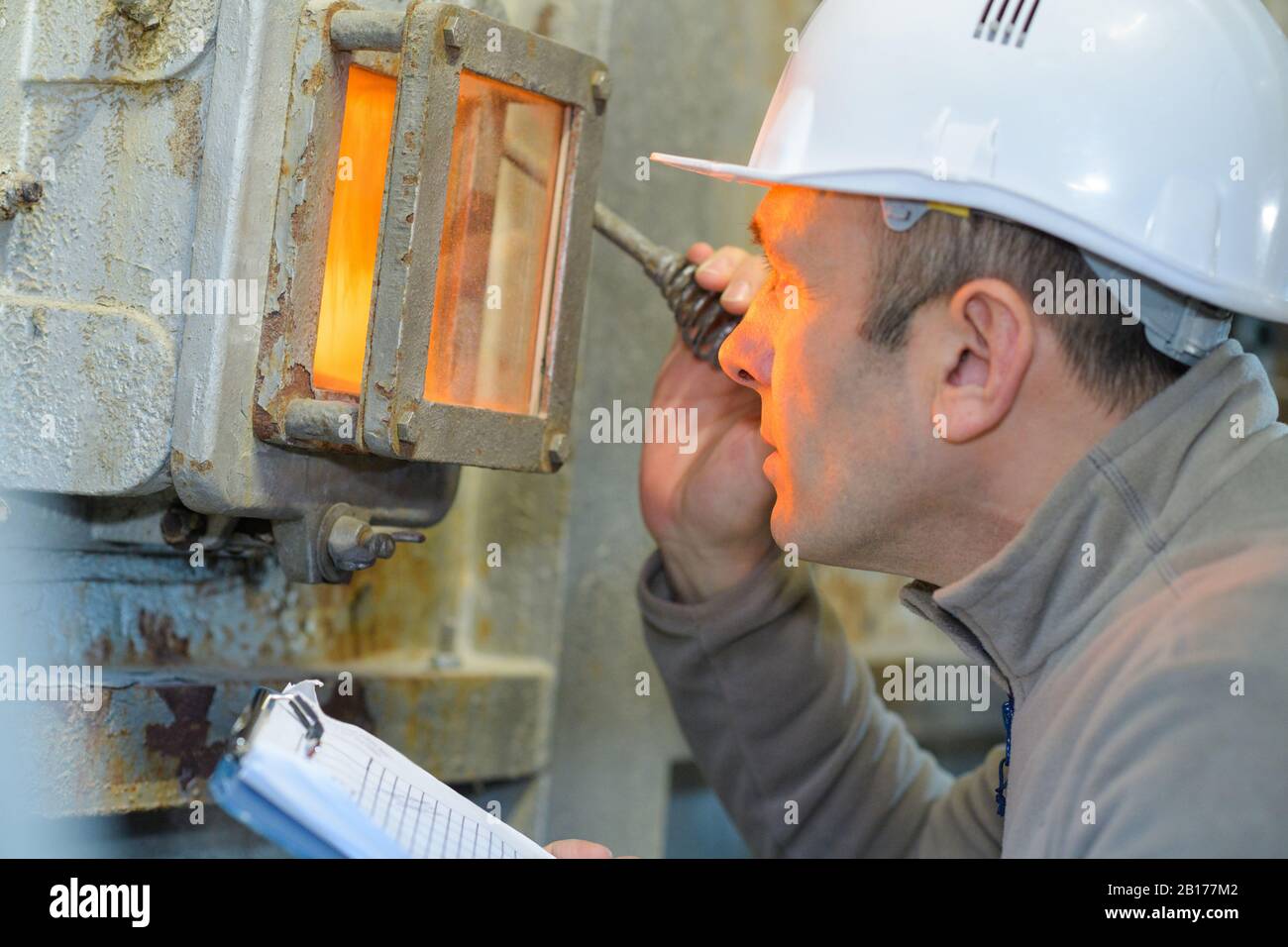 man looking through inspection glass of industrial incinerator Stock ...