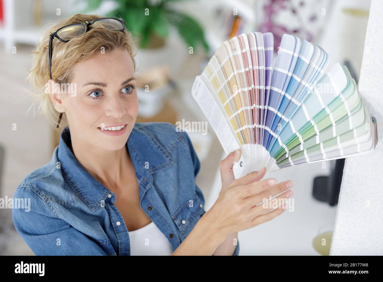 woman choosing color for wall from swatches in room Stock Photo - Alamy