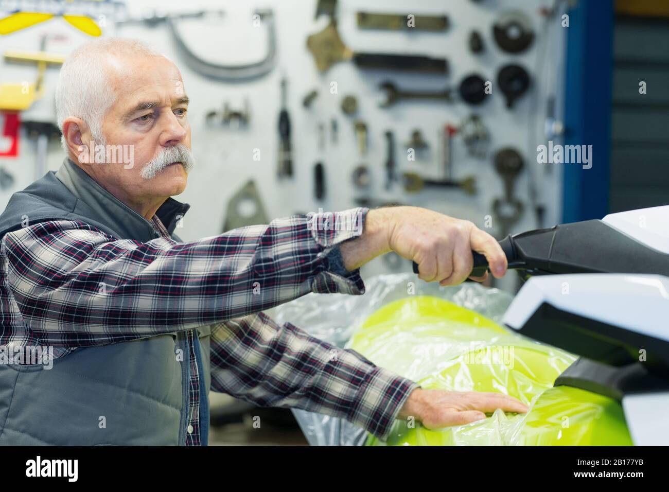 mechanic working on scooter Stock Photo - Alamy