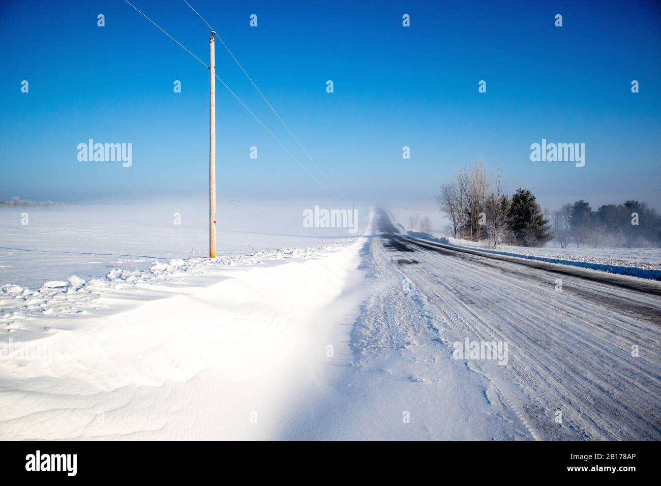 Wisconsin asphalt road covered with snow from the wind, horizontal ...