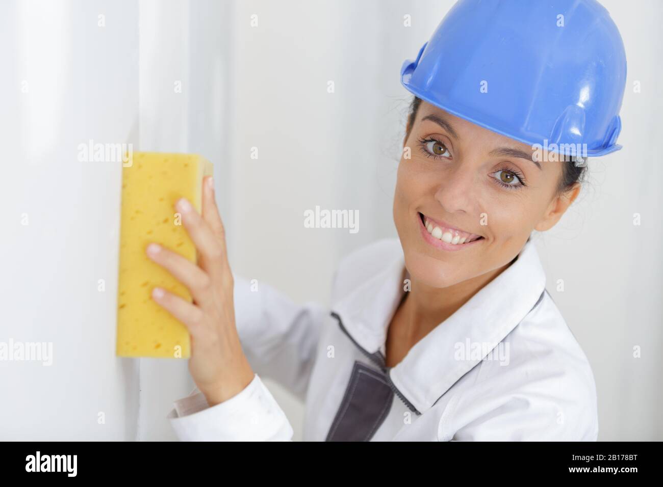 female builder washing the wall Stock Photo - Alamy