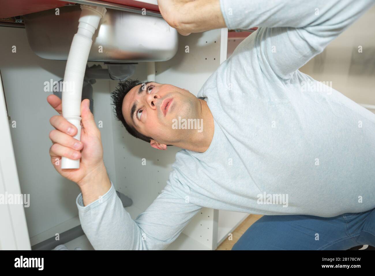 man fixing a pipe with a wrench Stock Photo - Alamy