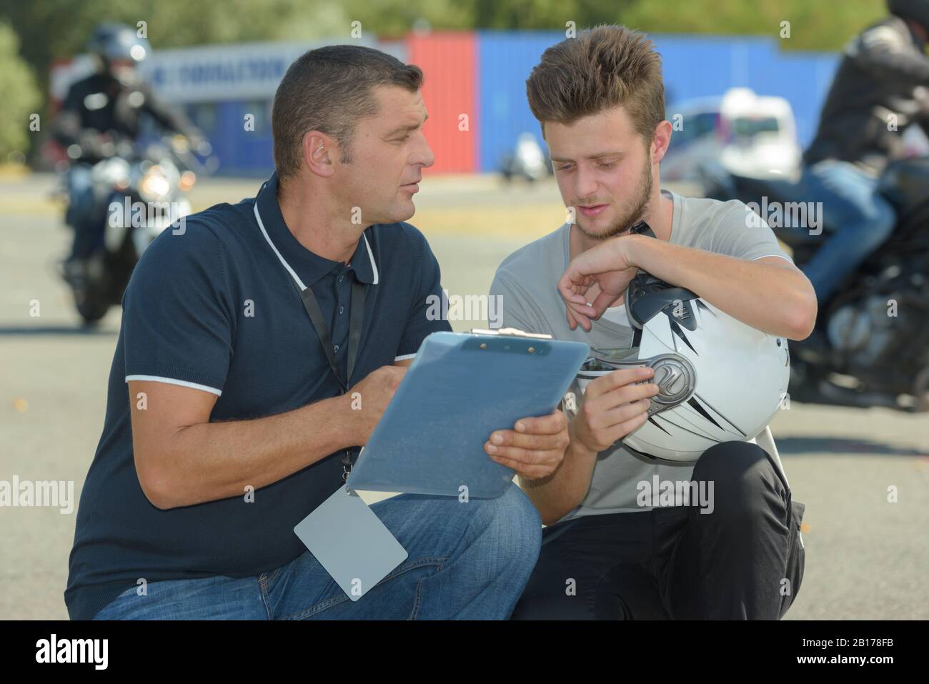 student and teacher talking before motorbike lesson Stock Photo - Alamy