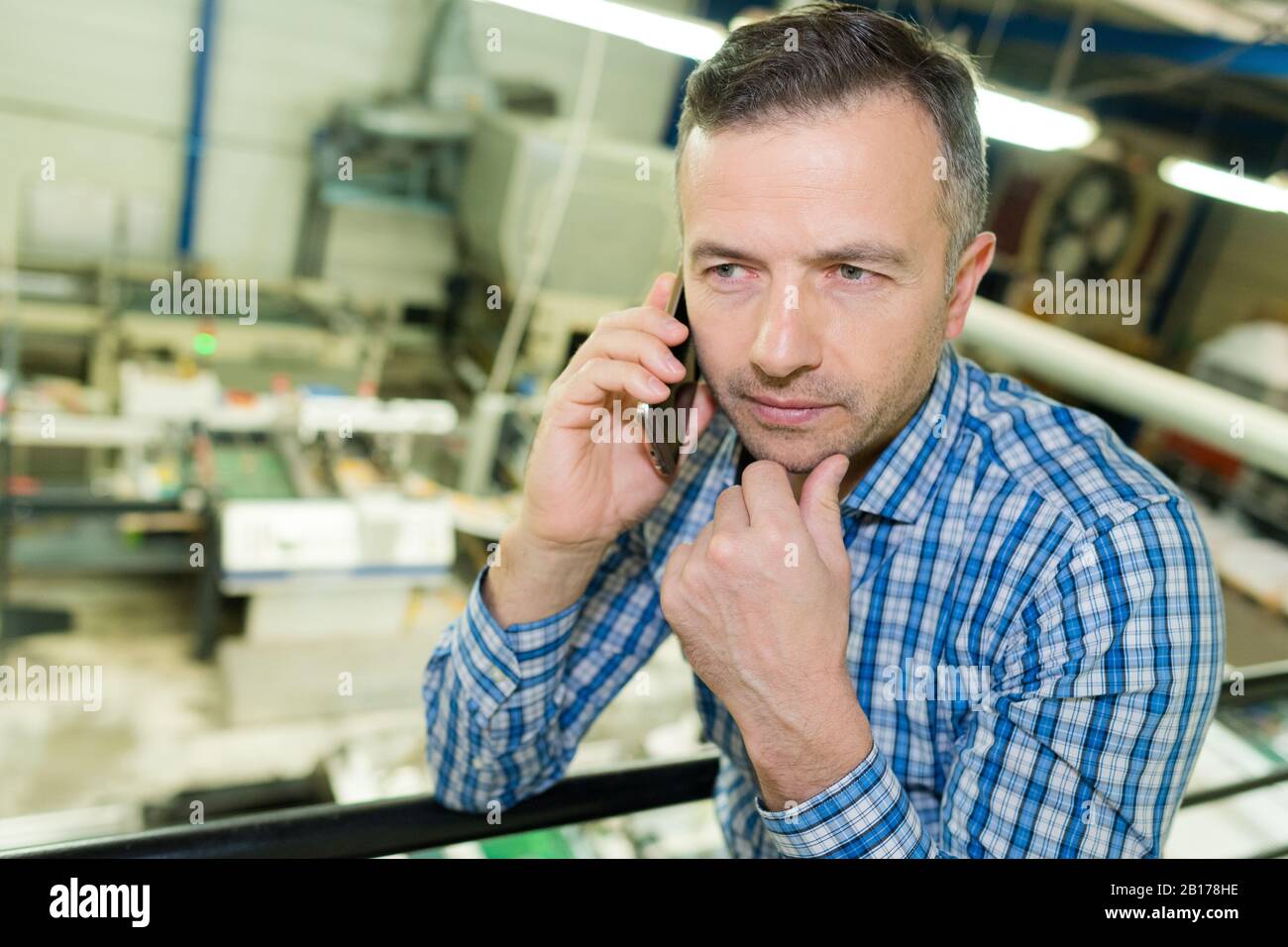 male supervisor talking on mobile phone in industry Stock Photo - Alamy