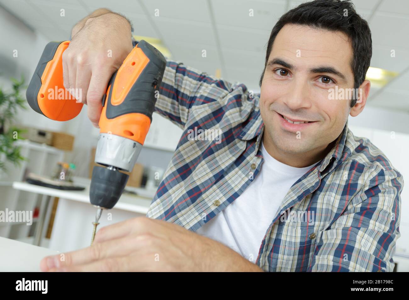happy man holding a cordless drill do it yourself tool Stock Photo - Alamy
