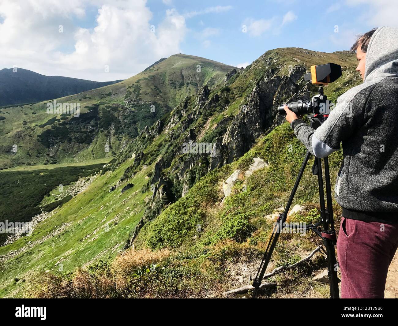 Back view cameraman shooting mountain landscape Stock Photo - Alamy