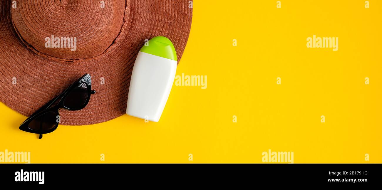 Suntan lotion in white bottle without labels, beach hat and sunglasses ...