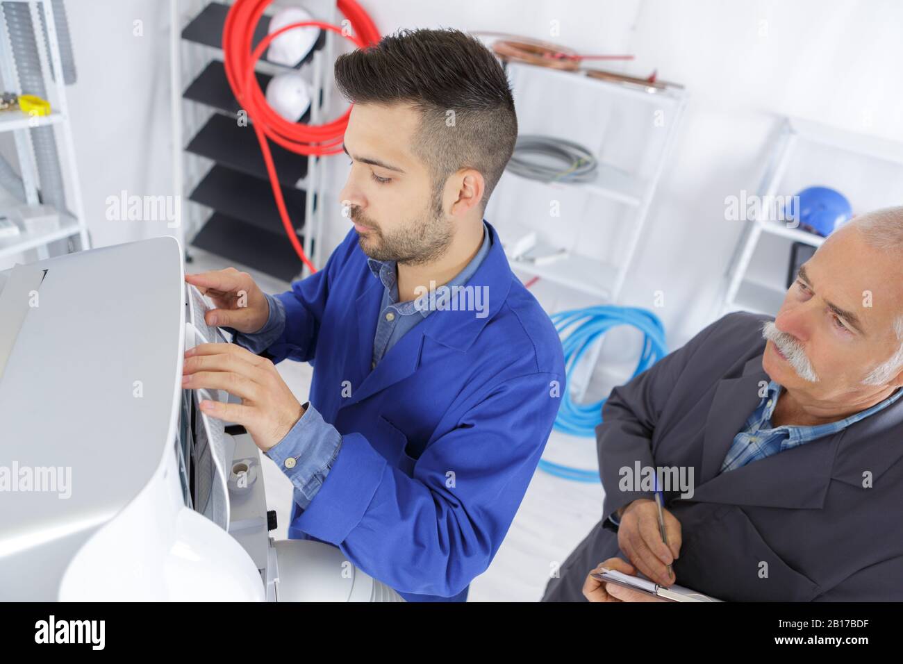 young male worker fixing a machine Stock Photo - Alamy