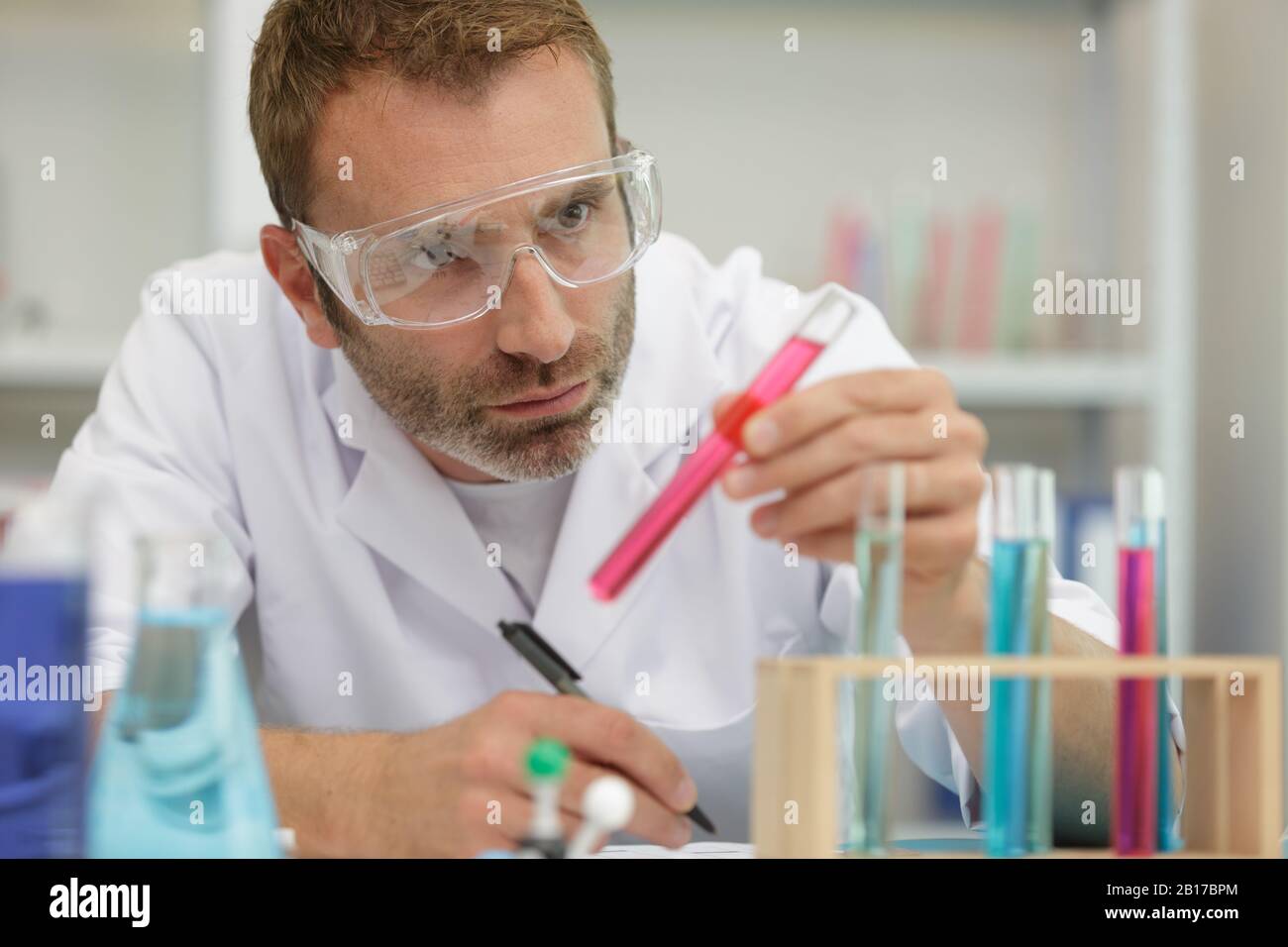 chemist man uses micro pipette to transfer liquid into bottle Stock ...