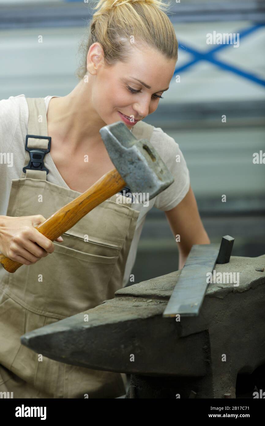 a woman holding metal hammer Stock Photo - Alamy