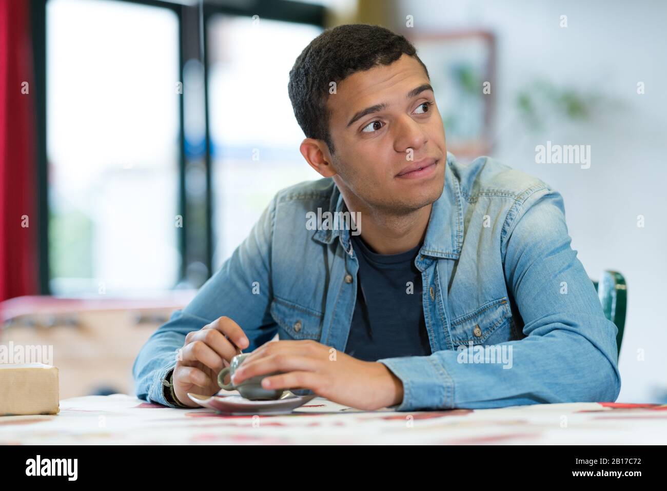 young man waiting sat at table in cafe Stock Photo - Alamy