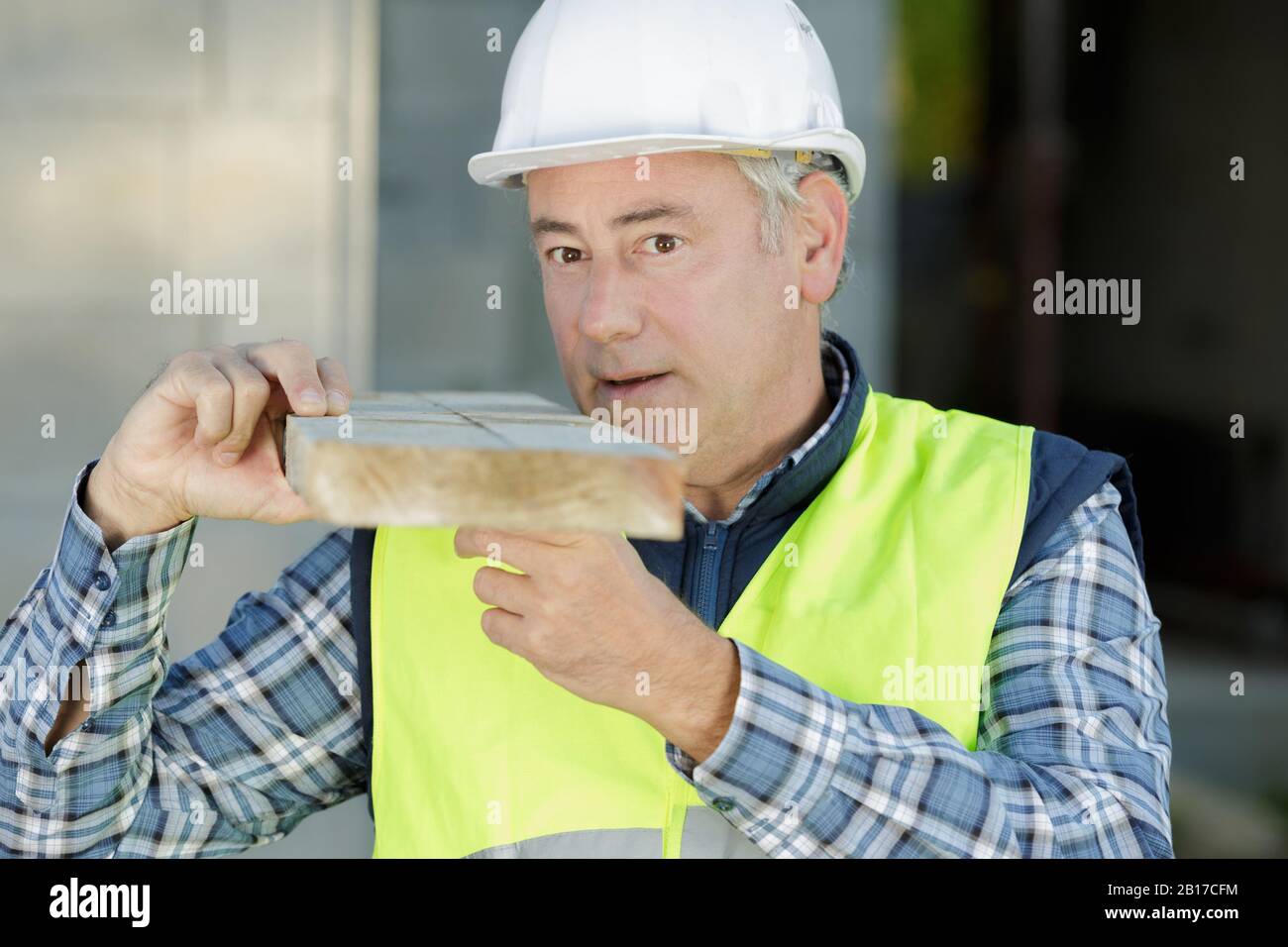 construction contractor carrying a beam Stock Photo - Alamy