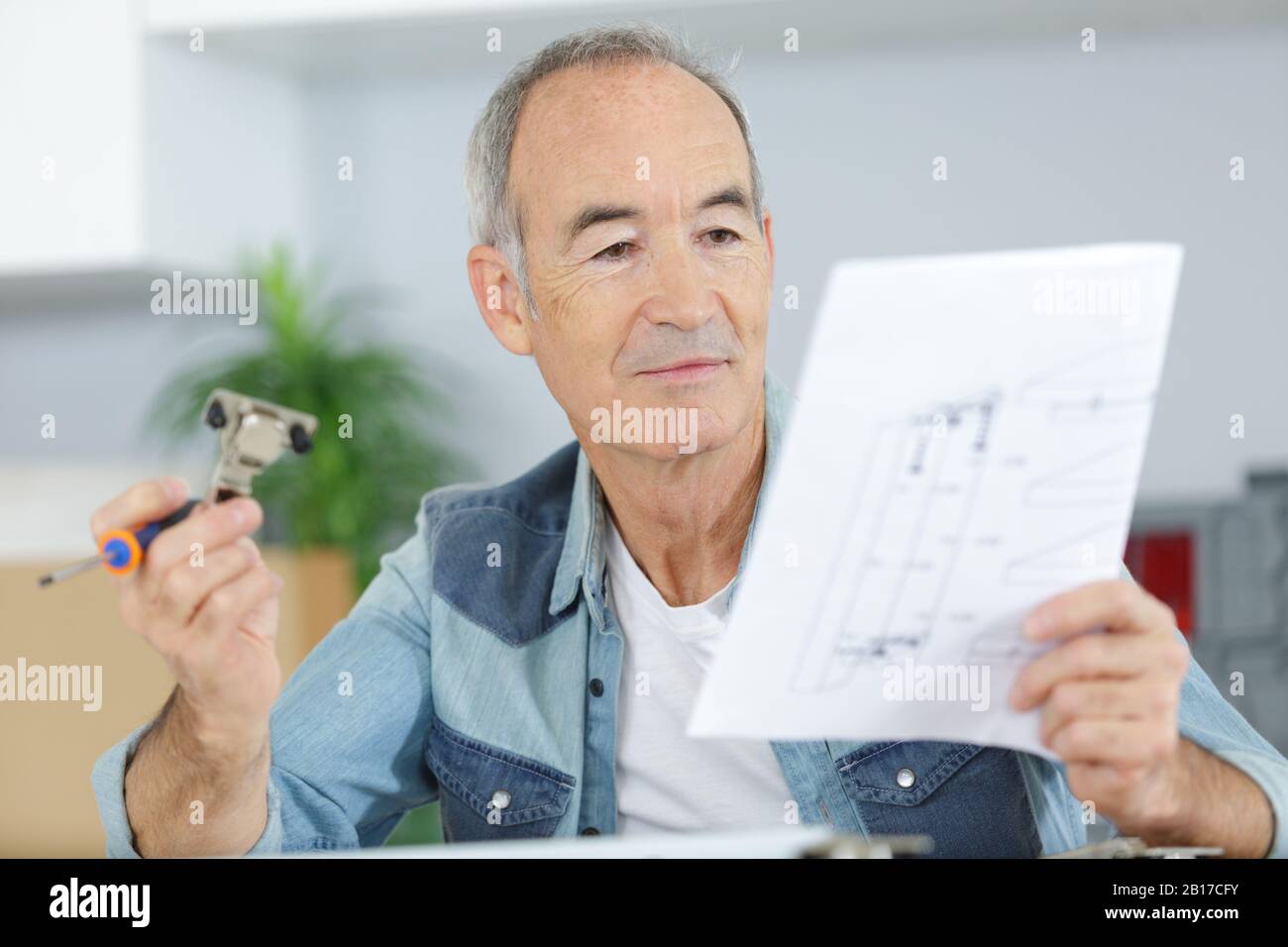 senior architect looking at construction plan in office Stock Photo - Alamy
