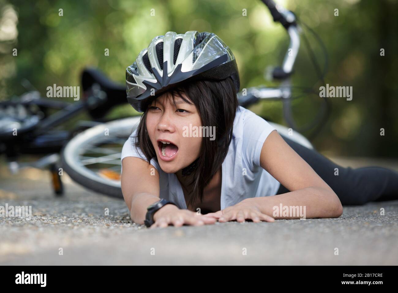 female biker fell from a bike Stock Photo - Alamy