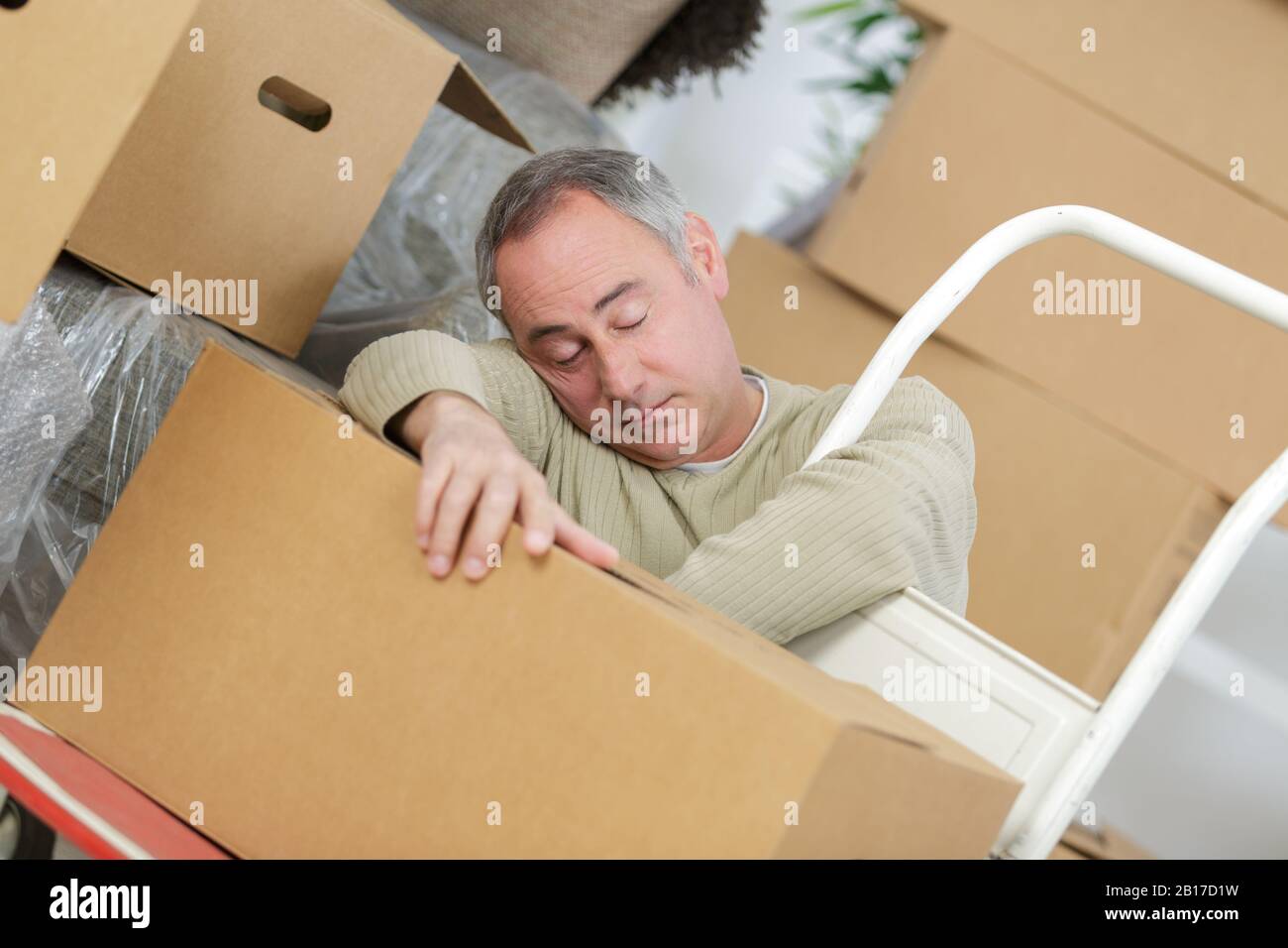 man holding boxes while sleeping Stock Photo - Alamy