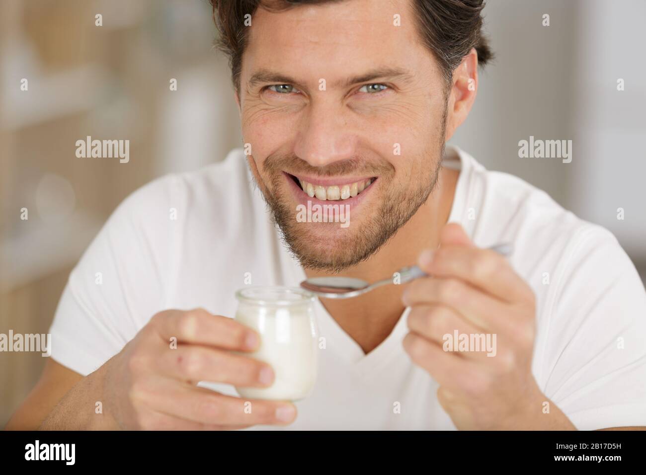Happy man eating yogurt hi-res stock photography and images - Alamy