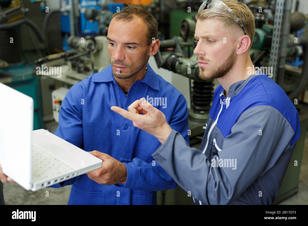 two mechanics work with the details of the car Stock Photo - Alamy