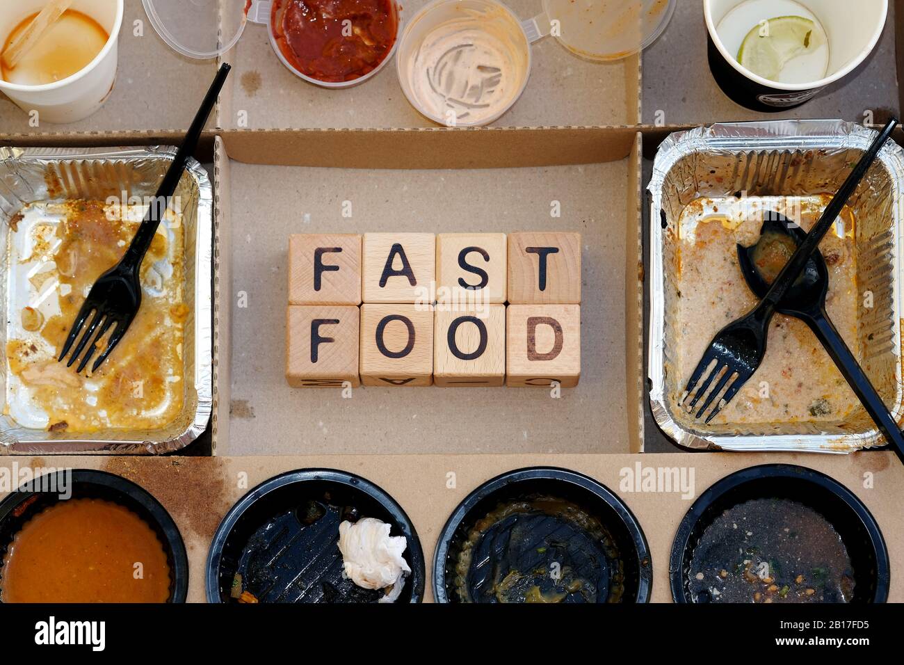 The inscription fast food on the box with dirty used dishes. Cardboard ...