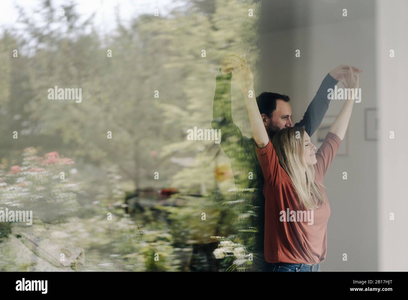 Couple looking out of window, touching hands Stock Photo - Alamy