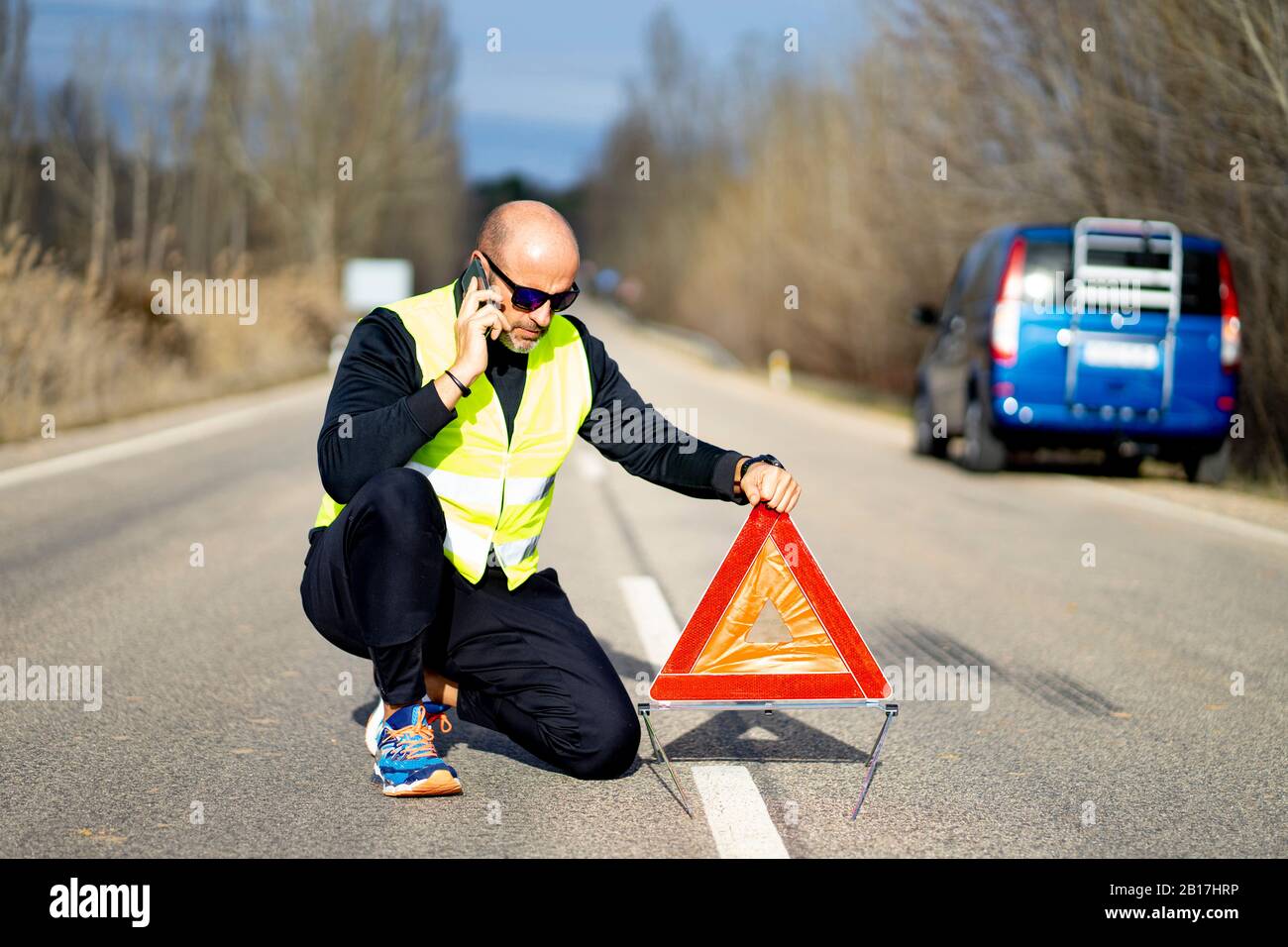 Man using a smartphone having a car breakdown Stock Photo - Alamy