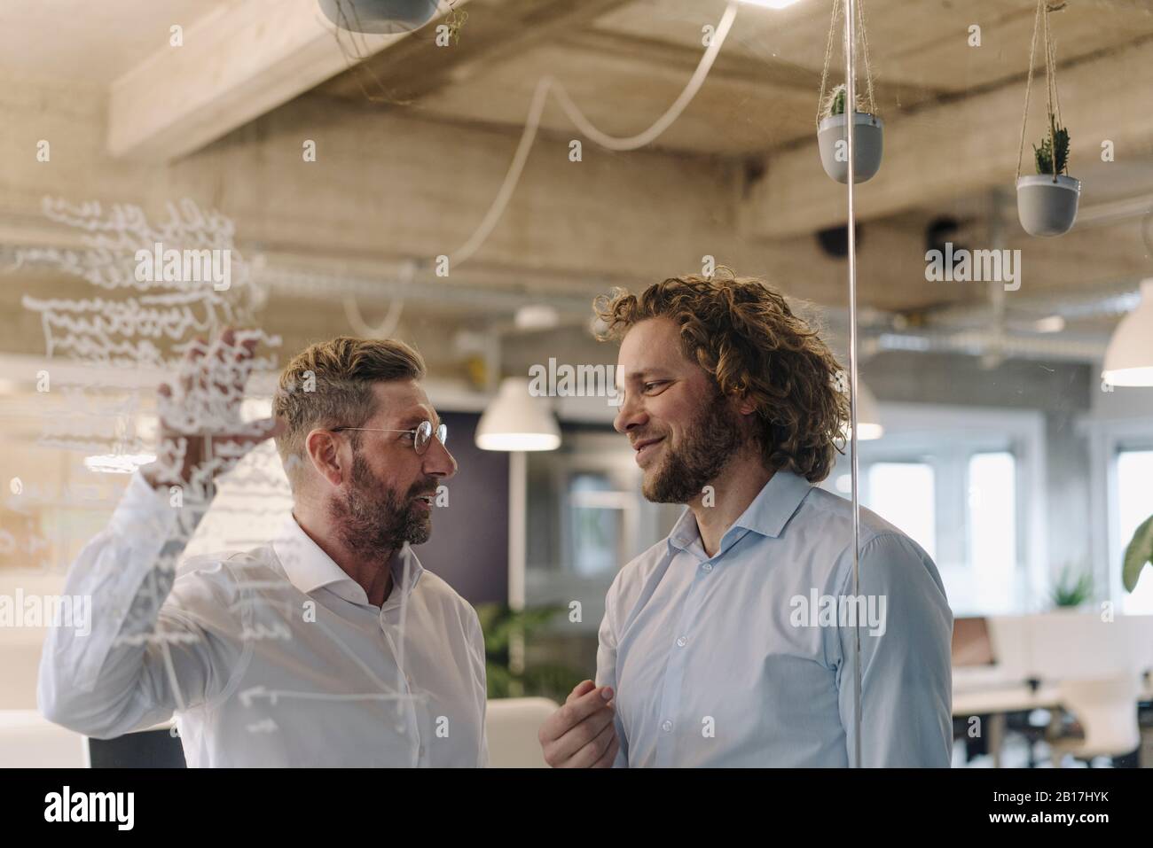 Two businessmen working on a project in office Stock Photo - Alamy