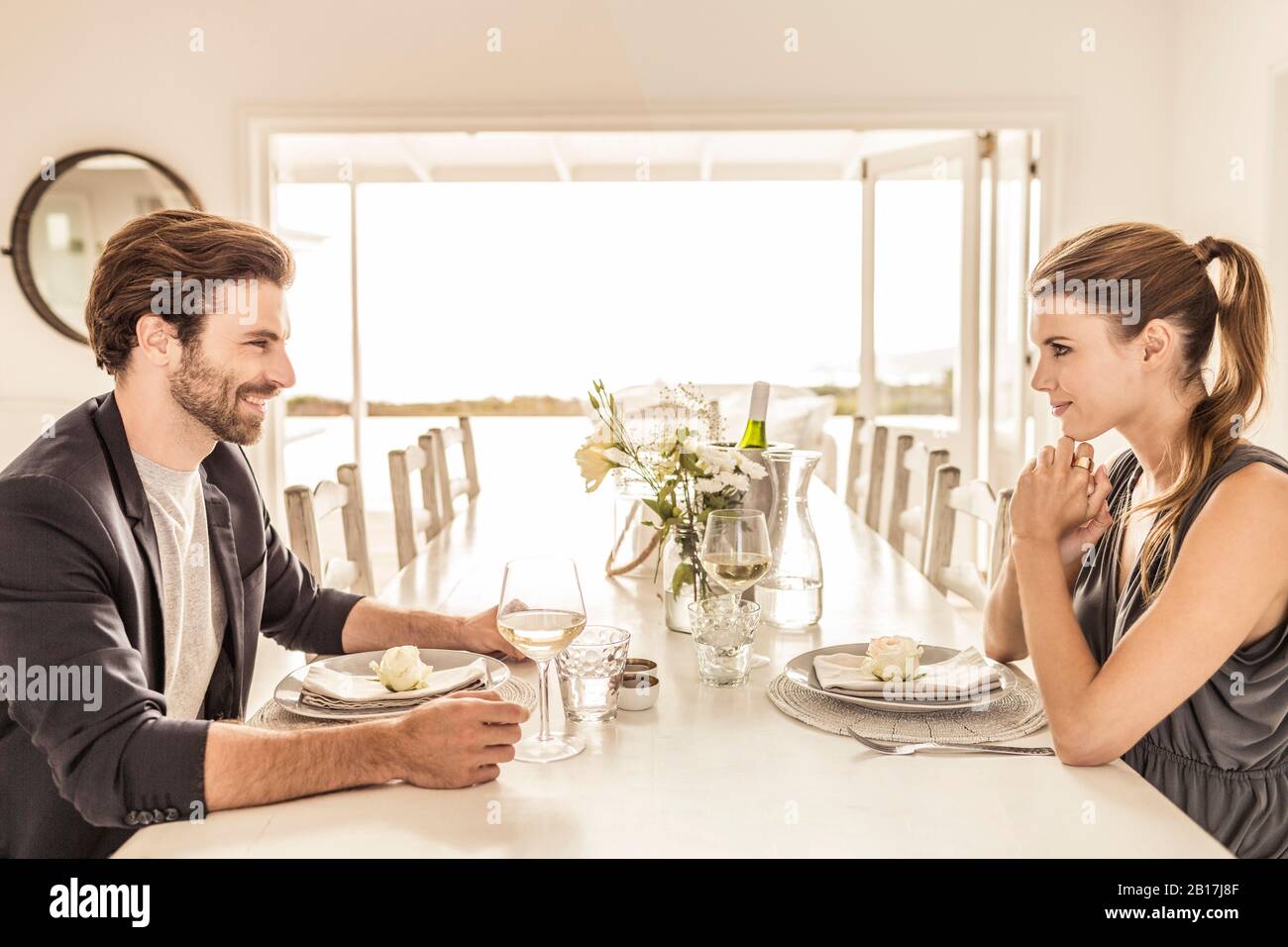 Happy young couple having dinner with view on terrace Stock Photo - Alamy