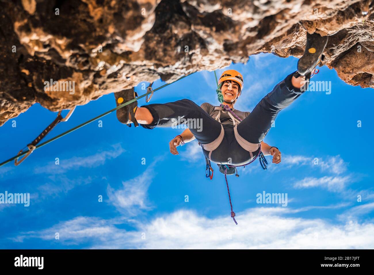 Portrait of smiling female climber abseiling from rock face Stock Photo ...