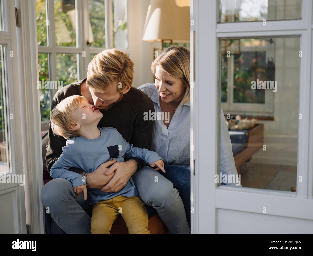 Happy and affectionate family in sunroom at home Stock Photo - Alamy