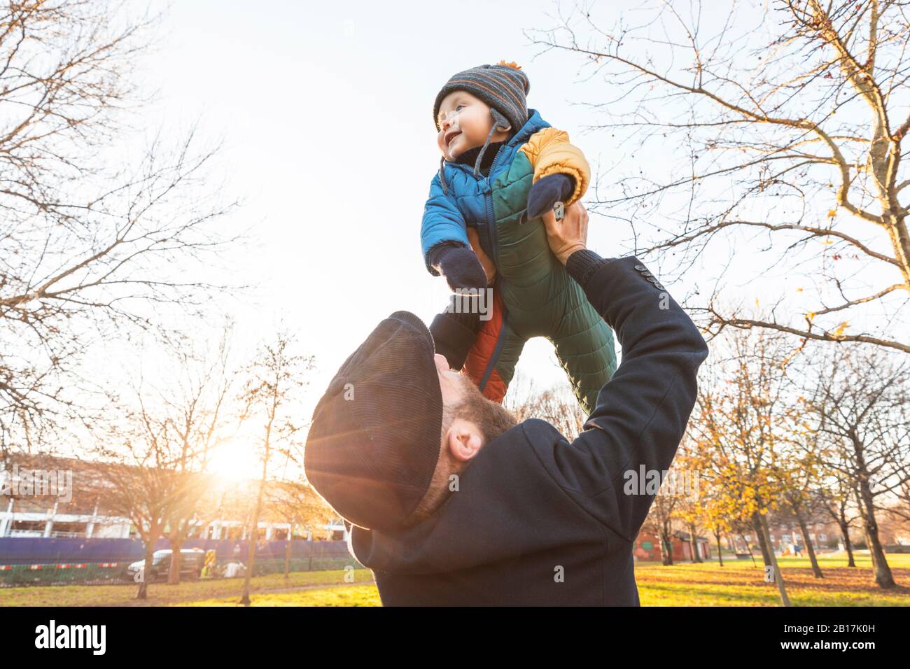 Man lifting up his happy baby son at park Stock Photo - Alamy