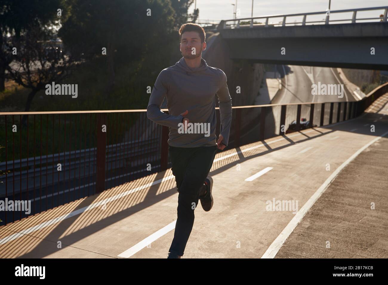 Man running on a road in sunlight Stock Photo - Alamy