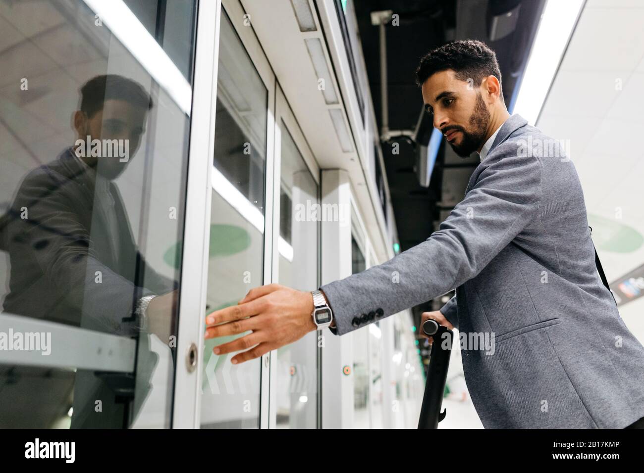 Young businessman pressing the opening button to get on an automatic ...