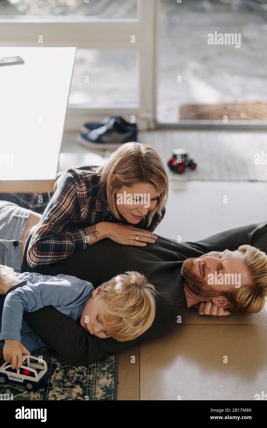 Happy relaxed family lying on the floor together at home Stock Photo ...