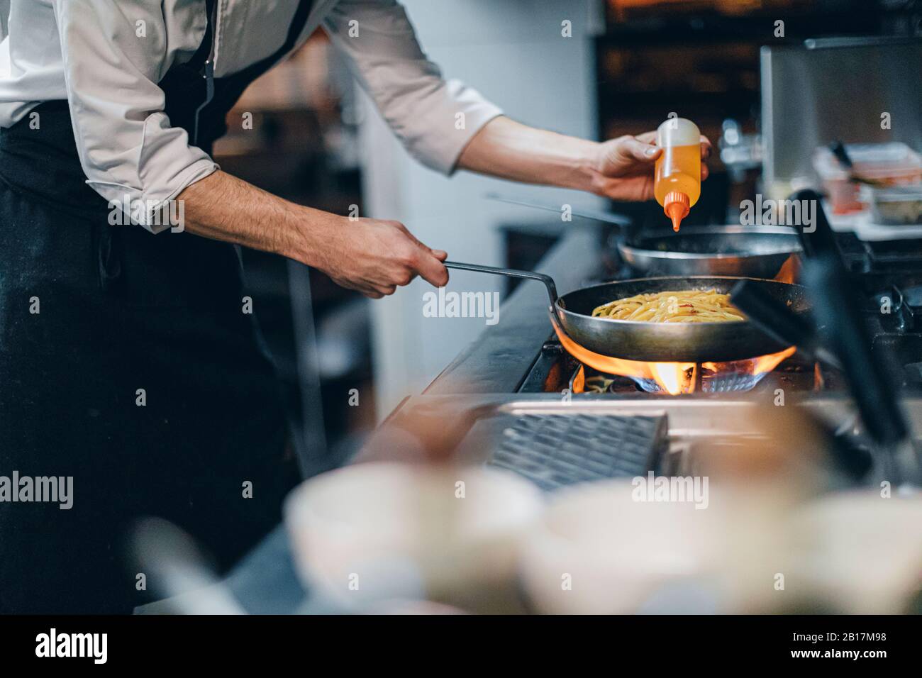Chef preparing a dish in traditional Italian restaurant kitchen Stock ...