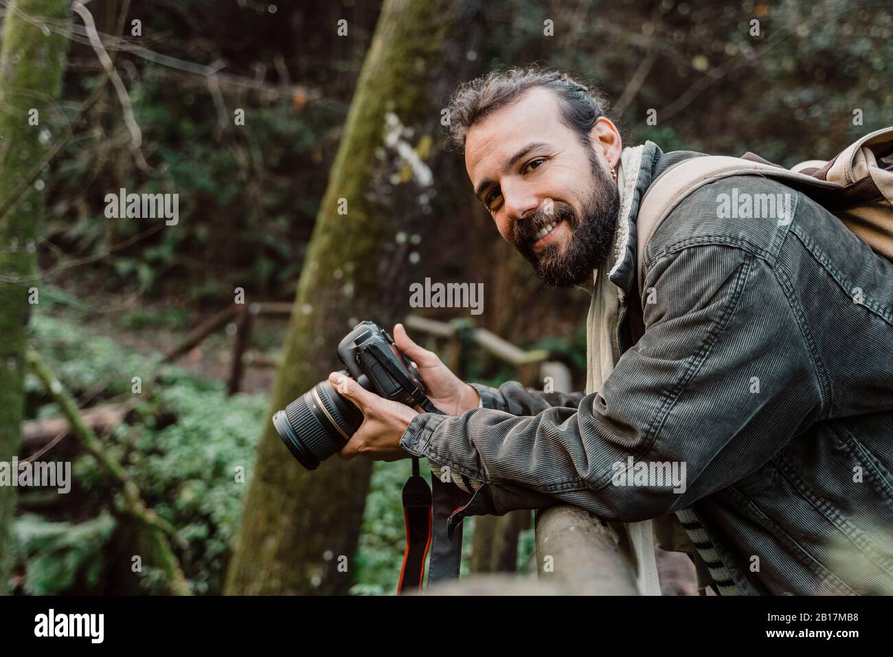 Young man taking pictures in the forest with his camera Stock Photo - Alamy