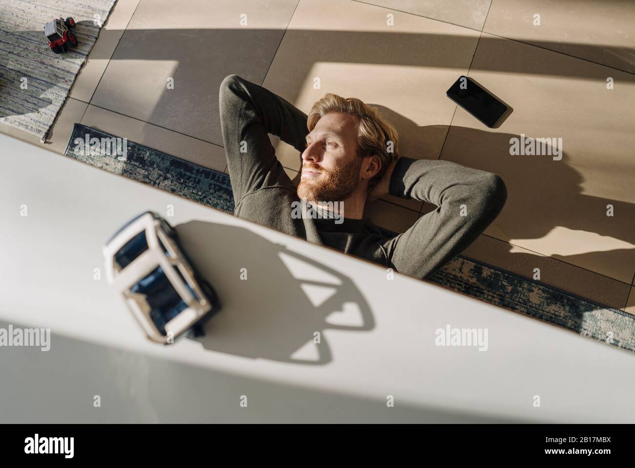 Relaxed man lying on the floor at home Stock Photo - Alamy